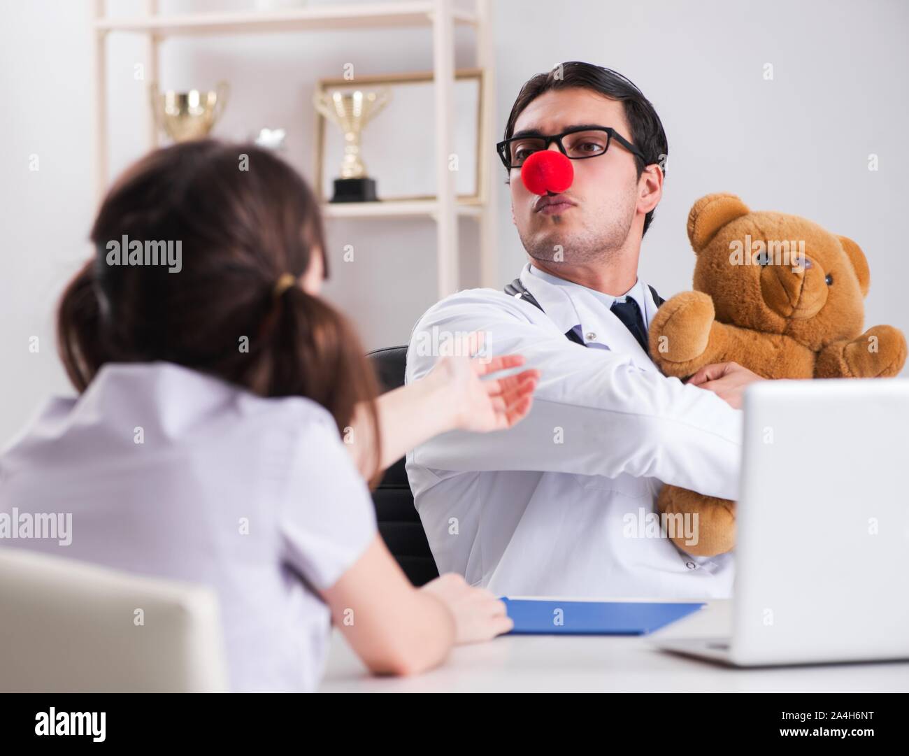 The funny pediatrician with little girl at regular check-up Stock Photo ...
