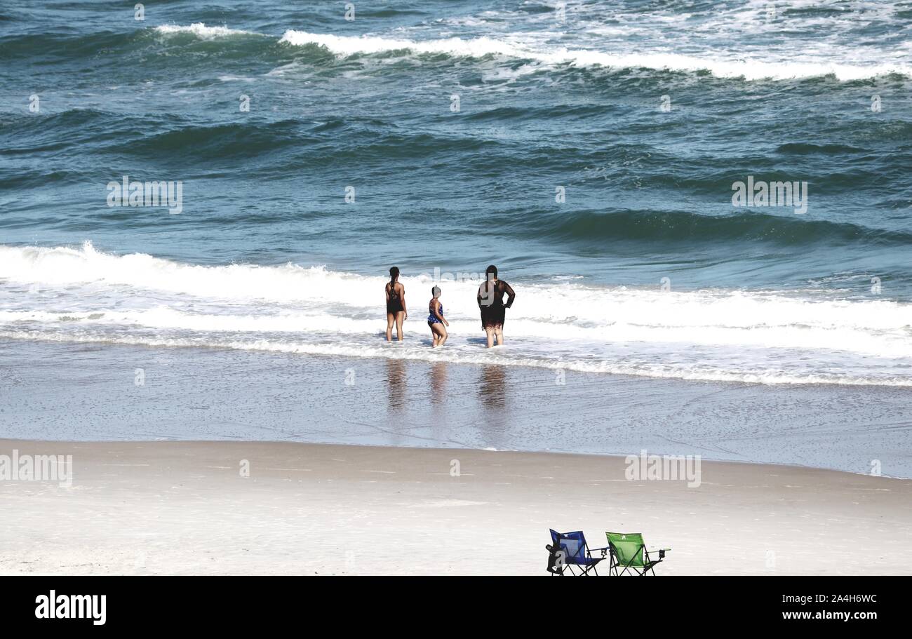 People on a sandy beach with a ocean background Stock Photo - Alamy