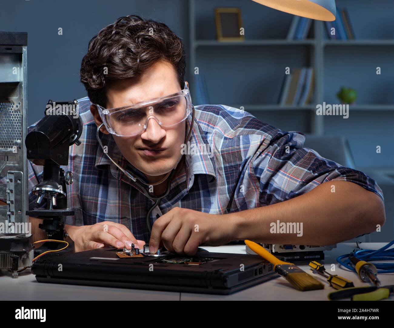 The computer repair concept with man inspecting with stethoscope Stock ...