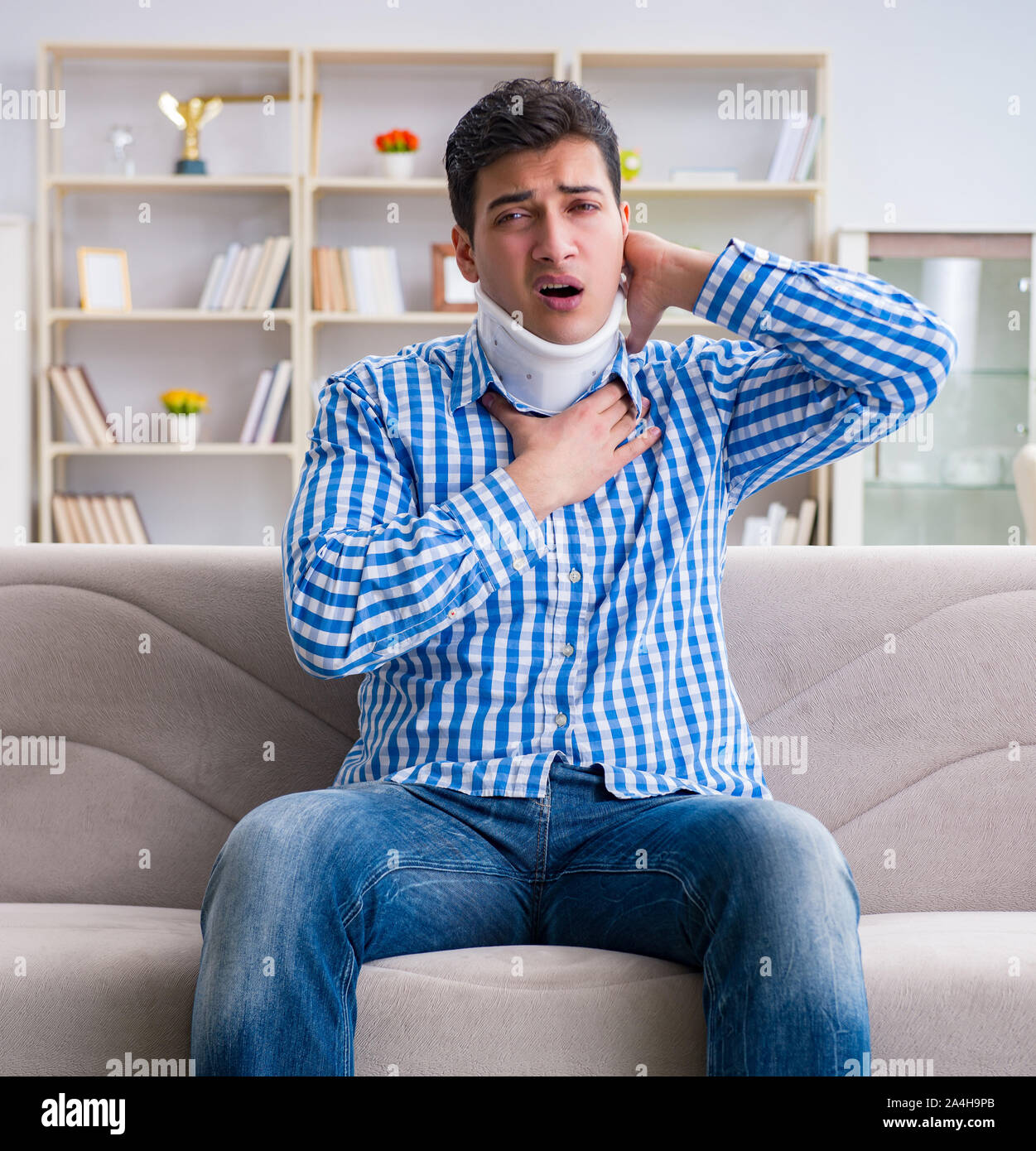 Young man suffering a neck spine head trauma wearing a cervical collar ...