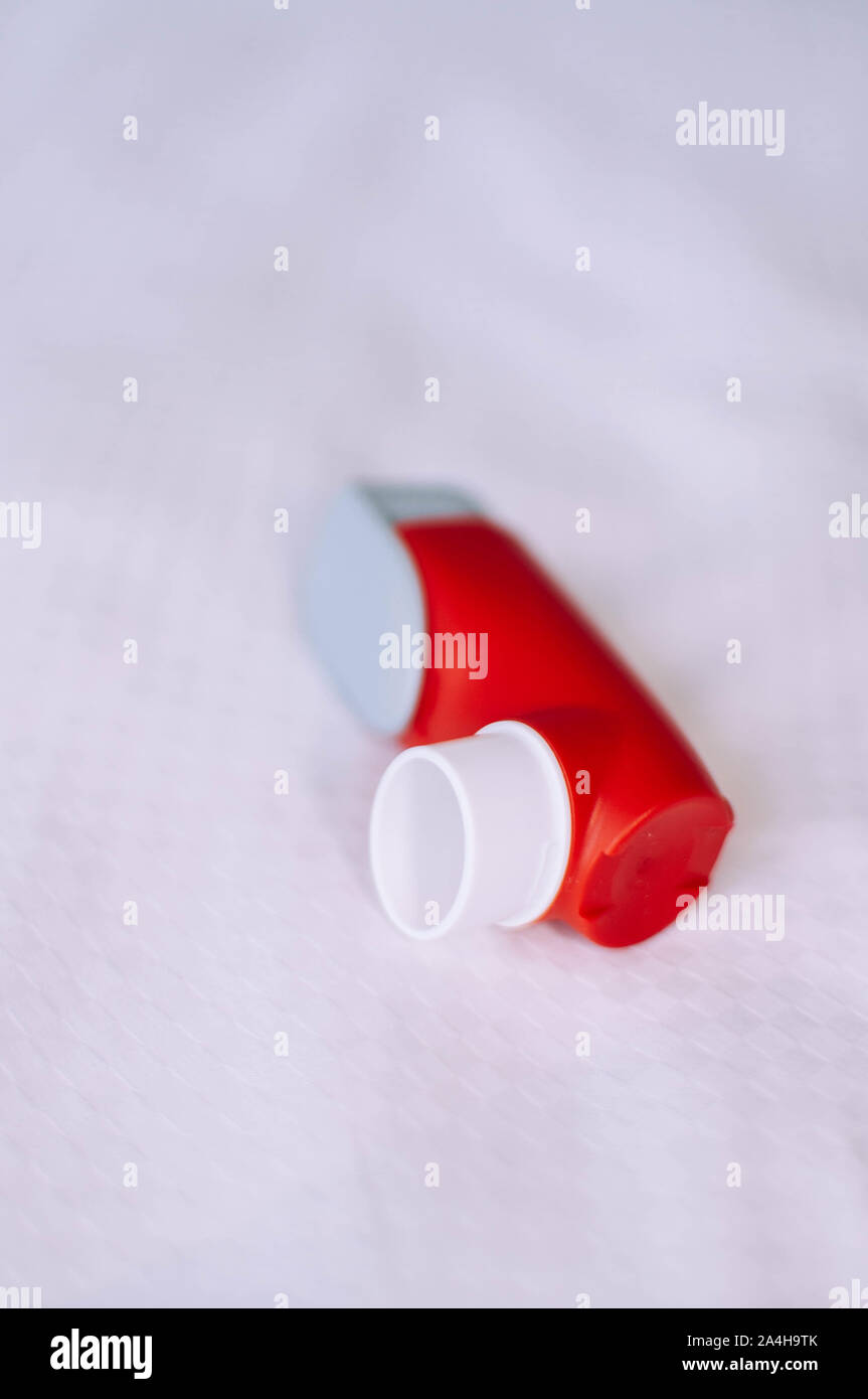 A still life of red and white asthma inhaler devise on a white ...