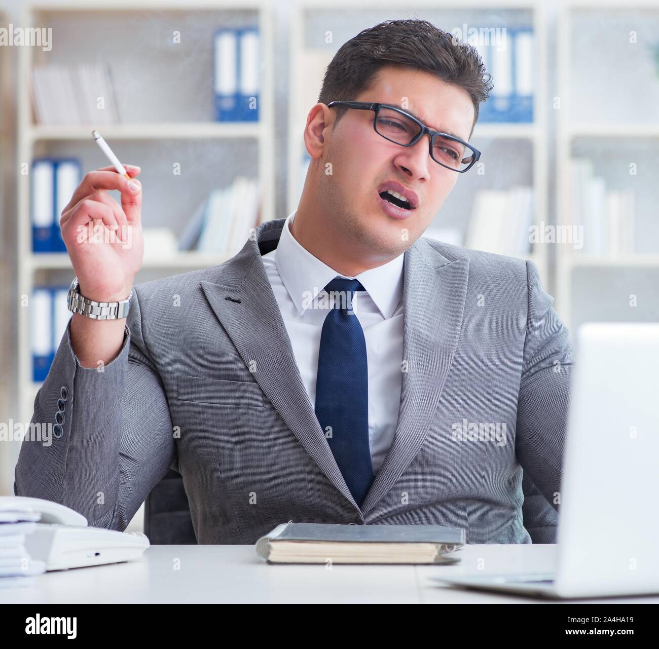 The businessman smoking in office at work Stock Photo - Alamy