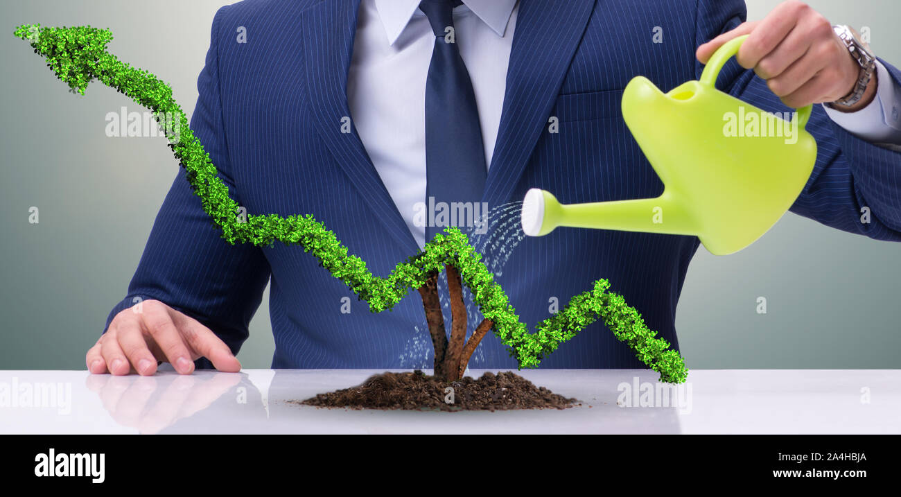 The businessman in investment concept watering financial line chart ...