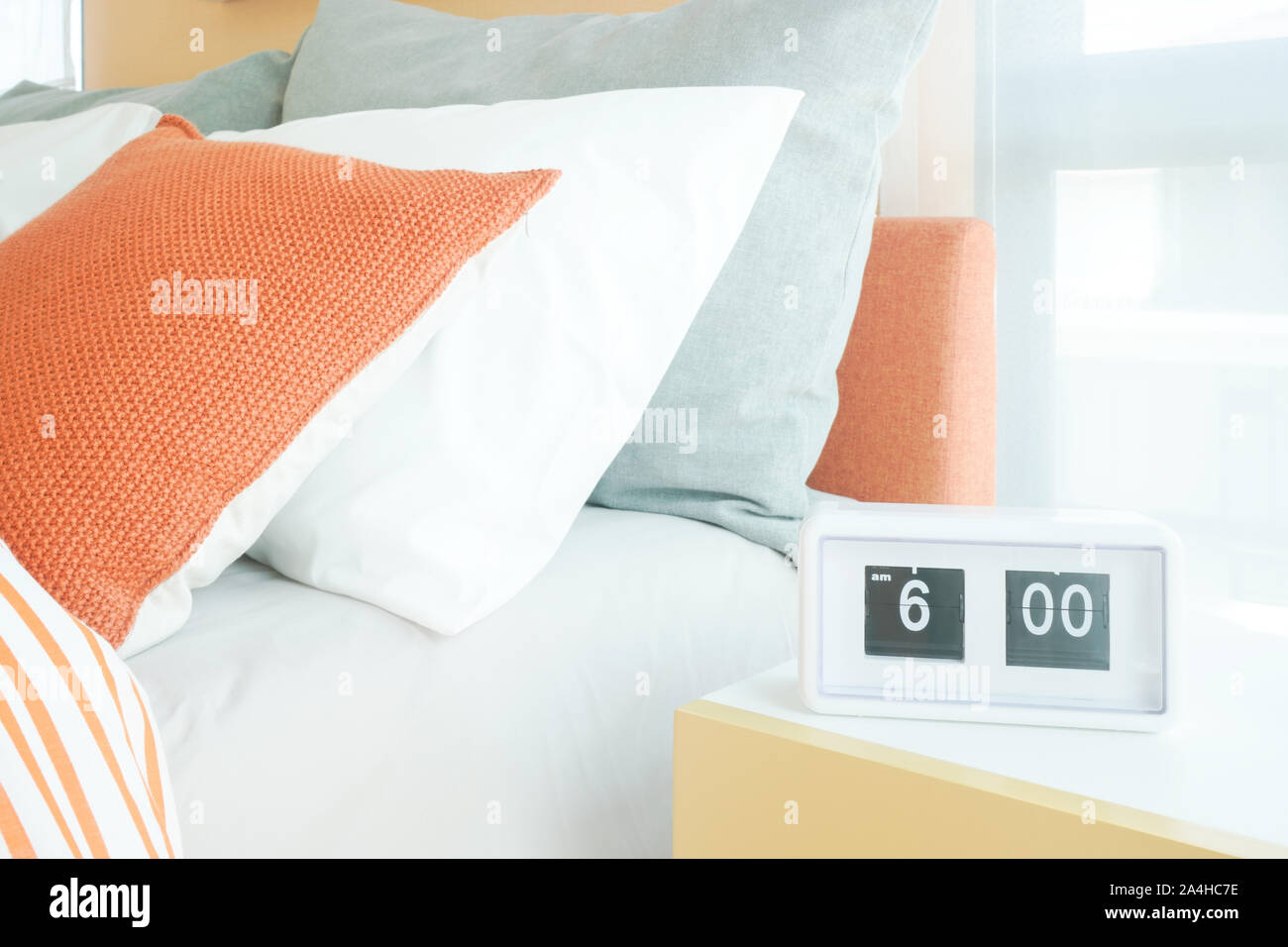 White modern alarm clock on night table next to bed Stock Photo - Alamy