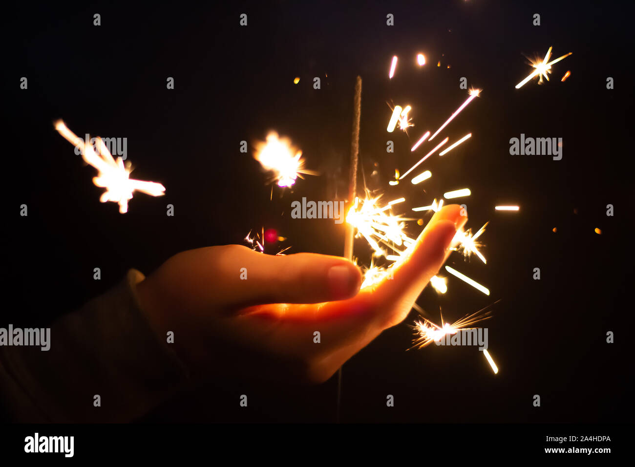 Hand holding sparkler, bright glowing sparks for celebrating events and ...