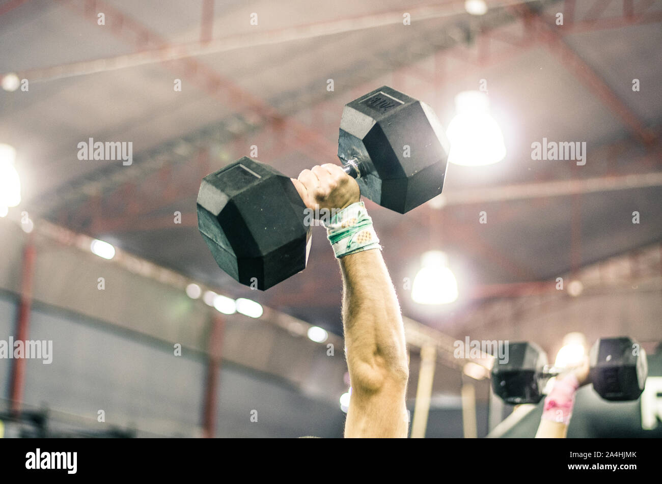 The hand of a muscular man lifting a dumbbell in the gym Stock Photo ...