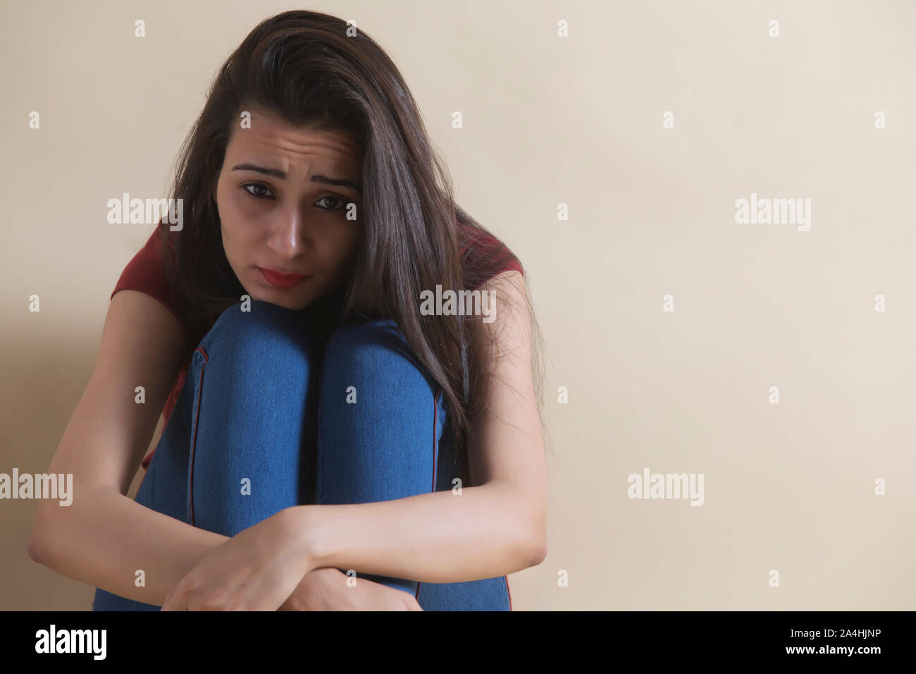 Young girl sitting alone in distress Stock Photo - Alamy