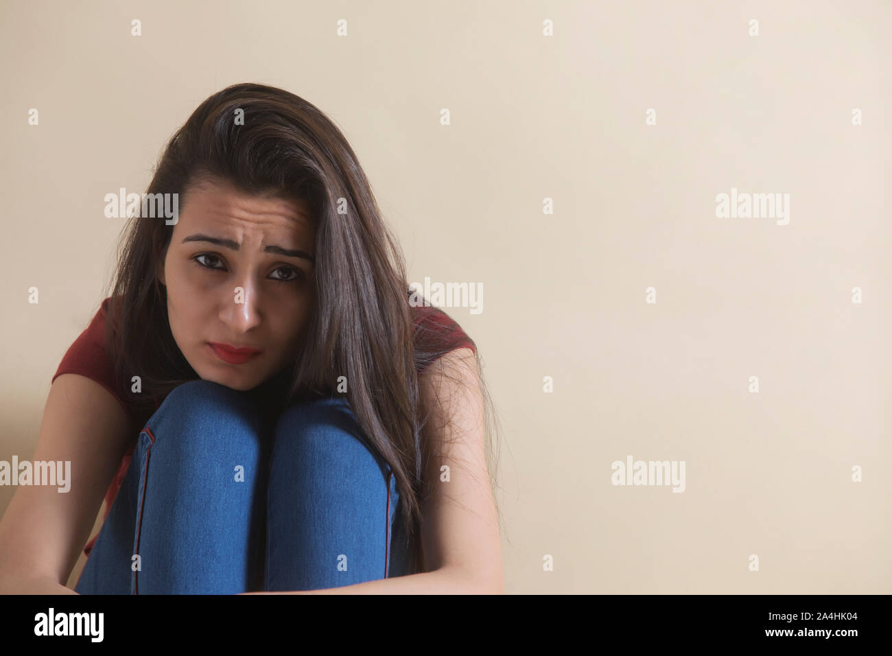 Young girl sitting alone in distress Stock Photo - Alamy