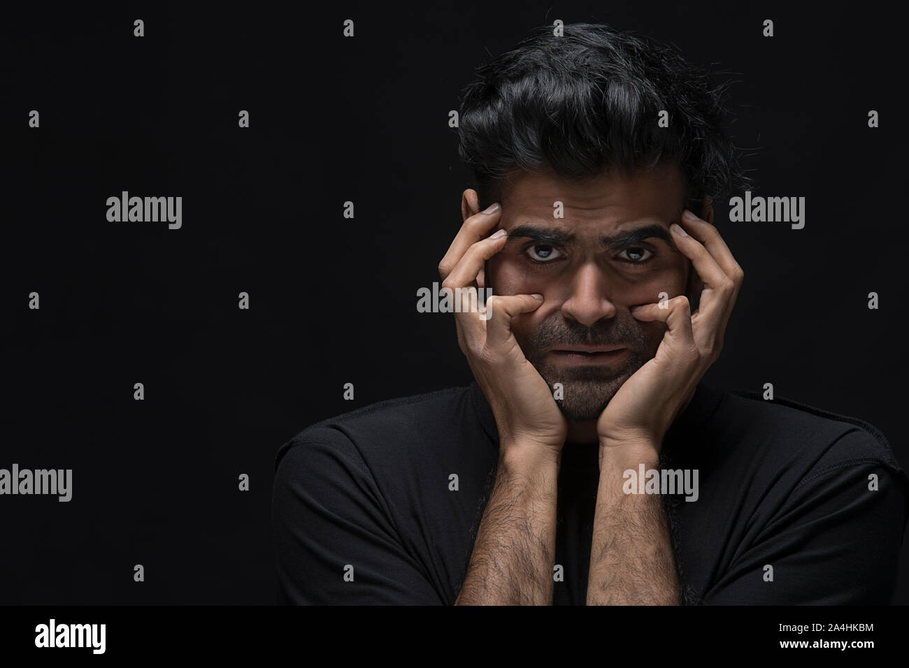 Closeup of a stressed young man holding his face stress Stock Photo - Alamy