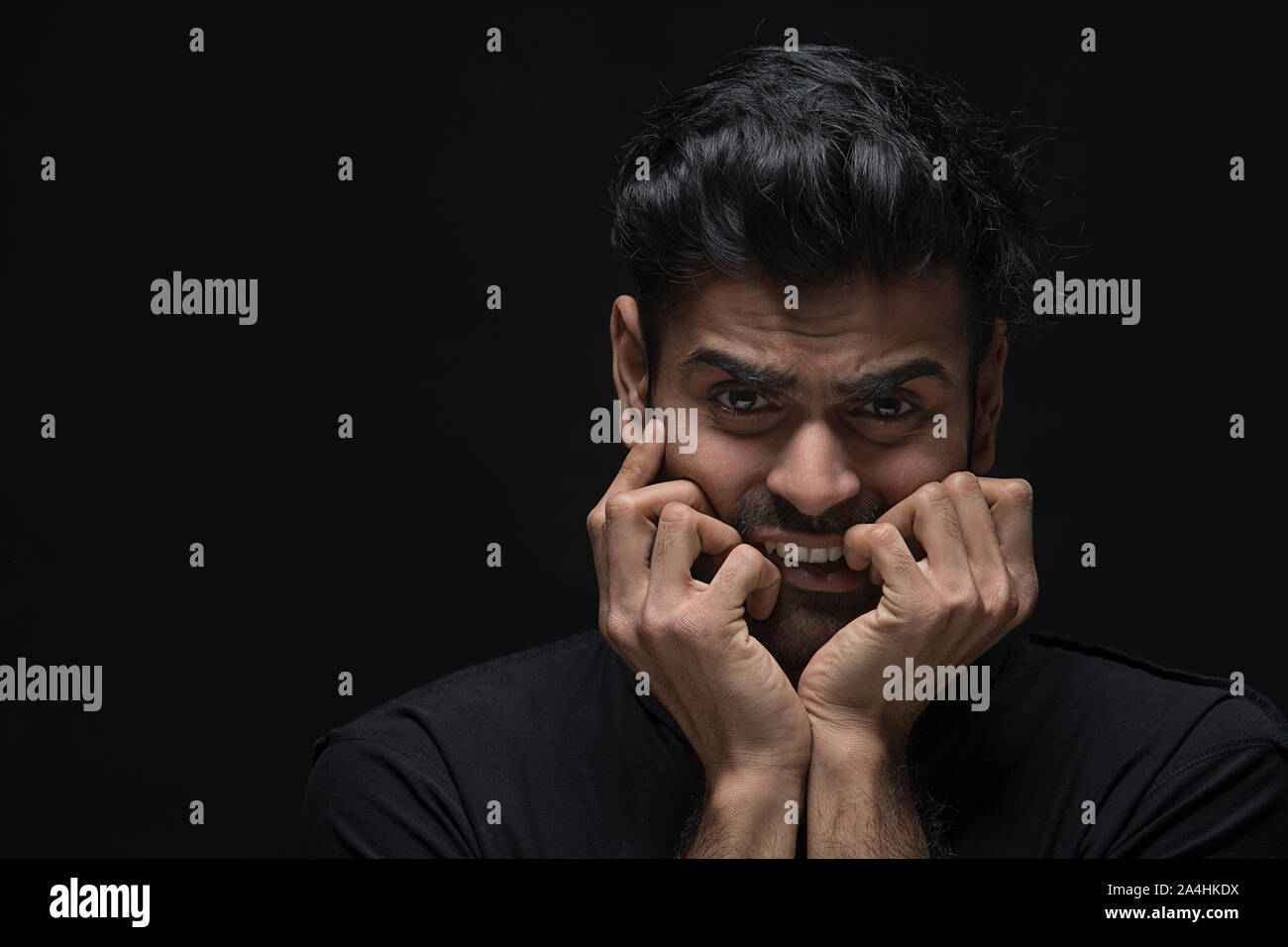 Closeup of a stressed young man holding his face stress Stock Photo - Alamy
