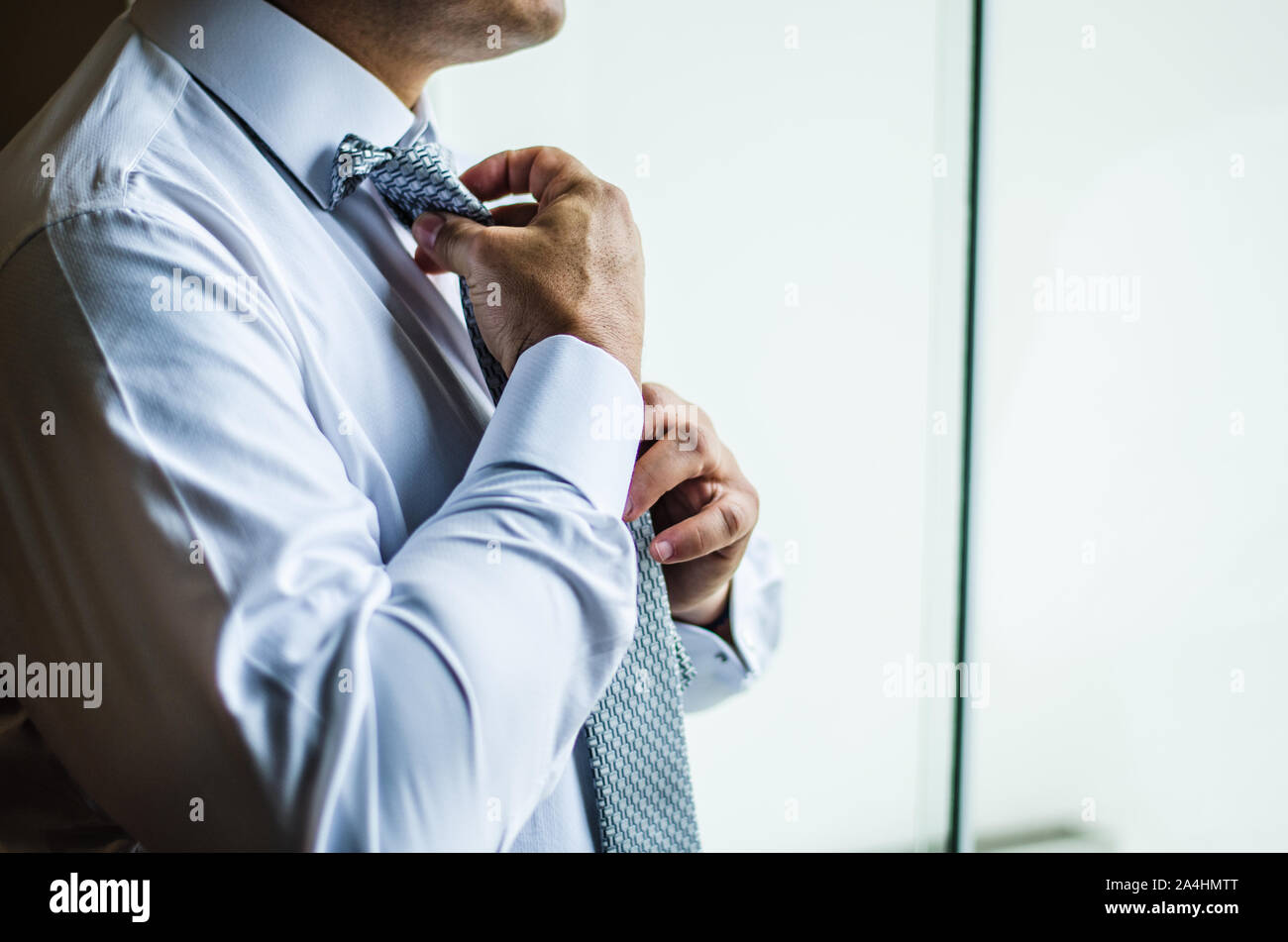 Businessman making a tie knot, formal suit Stock Photo - Alamy
