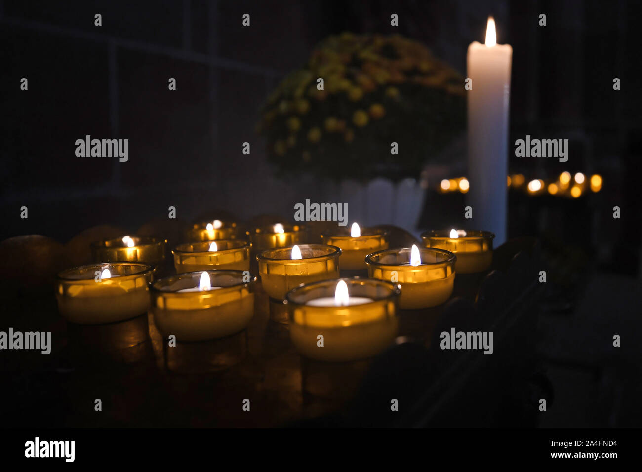Small votive or prayer candles burning as a votive offering in an act ...