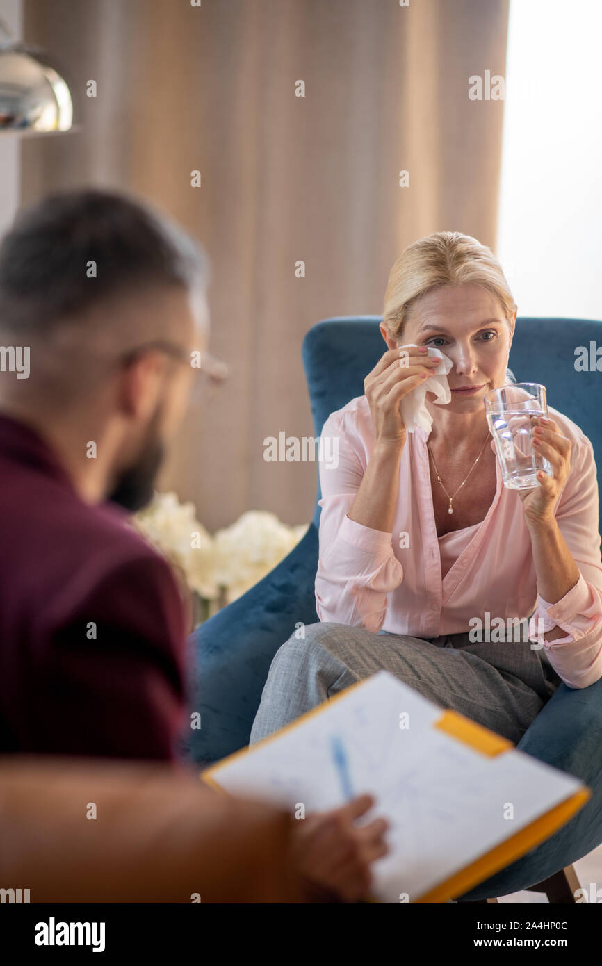 Woman crying and drinking water while listening to psychoanalyst Stock ...