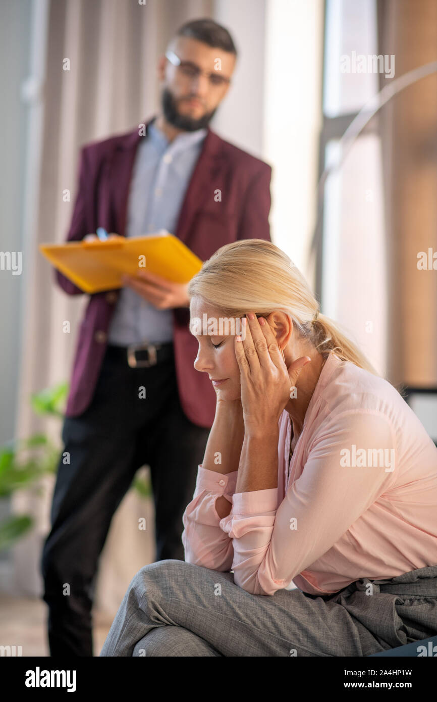 Blonde woman feeling confused while visiting psychoanalyst Stock Photo ...