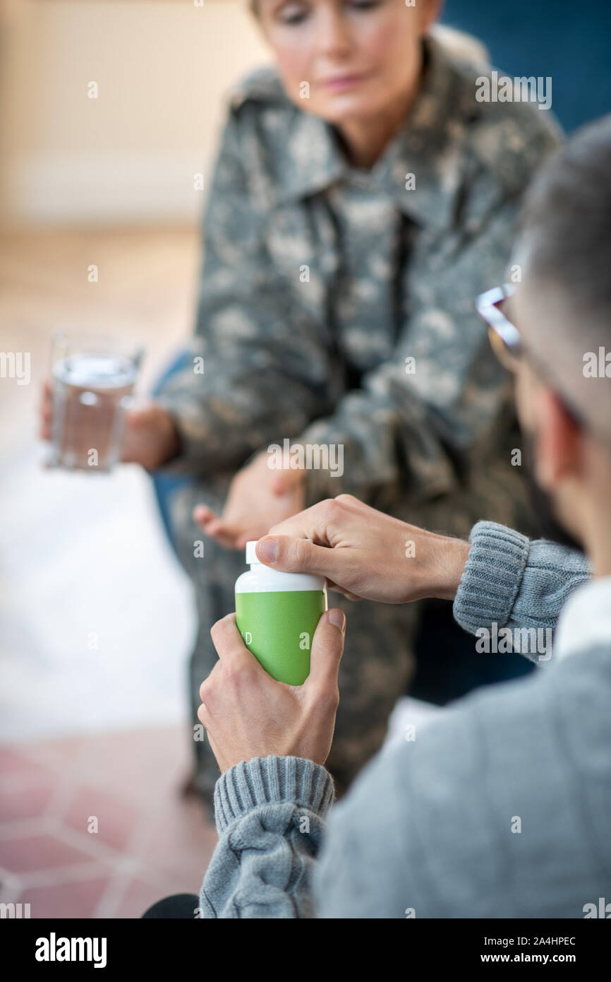 Psychologist holding pack of pills for military woman Stock Photo - Alamy