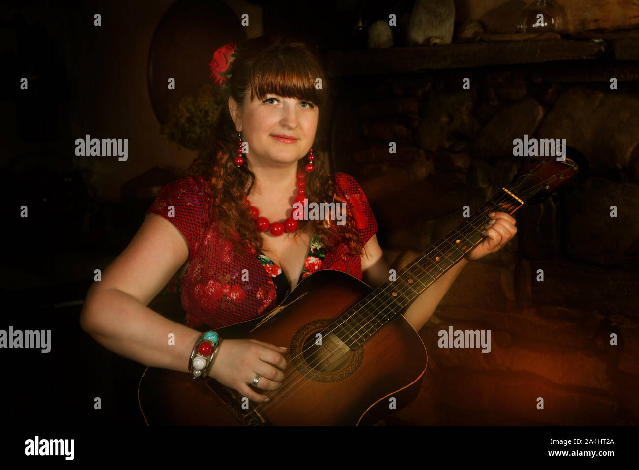 Beautiful young gypsy woman plays the guitar Stock Photo - Alamy