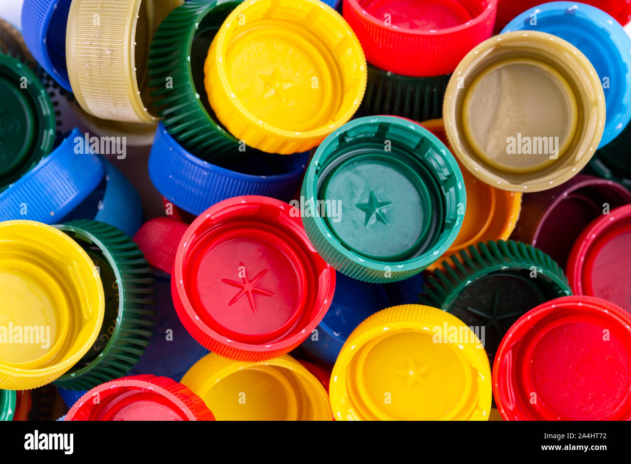 multicolored plastic bottle caps are scattered as a background. place ...