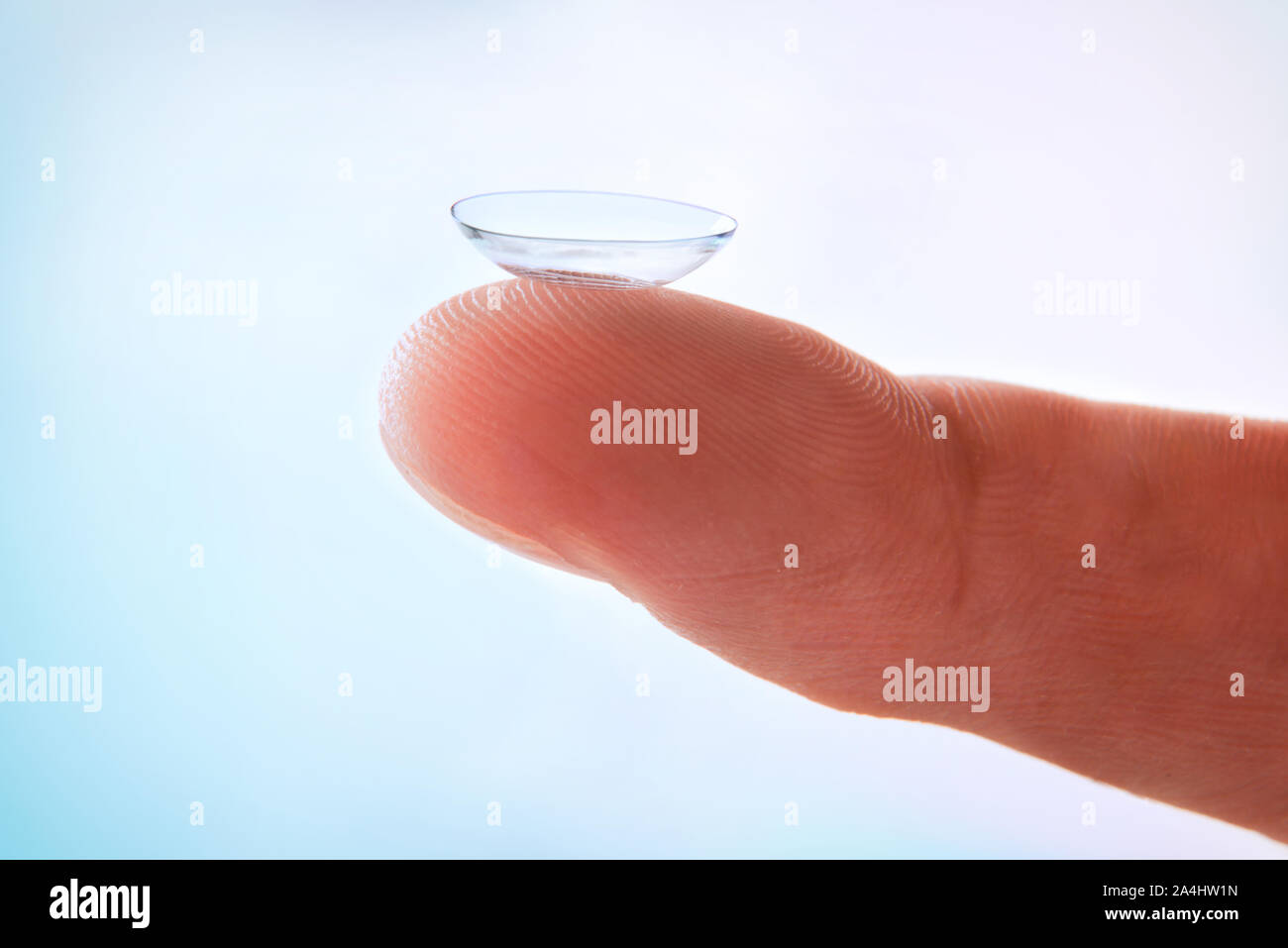Finger detail with contact lens with isolated white background ...