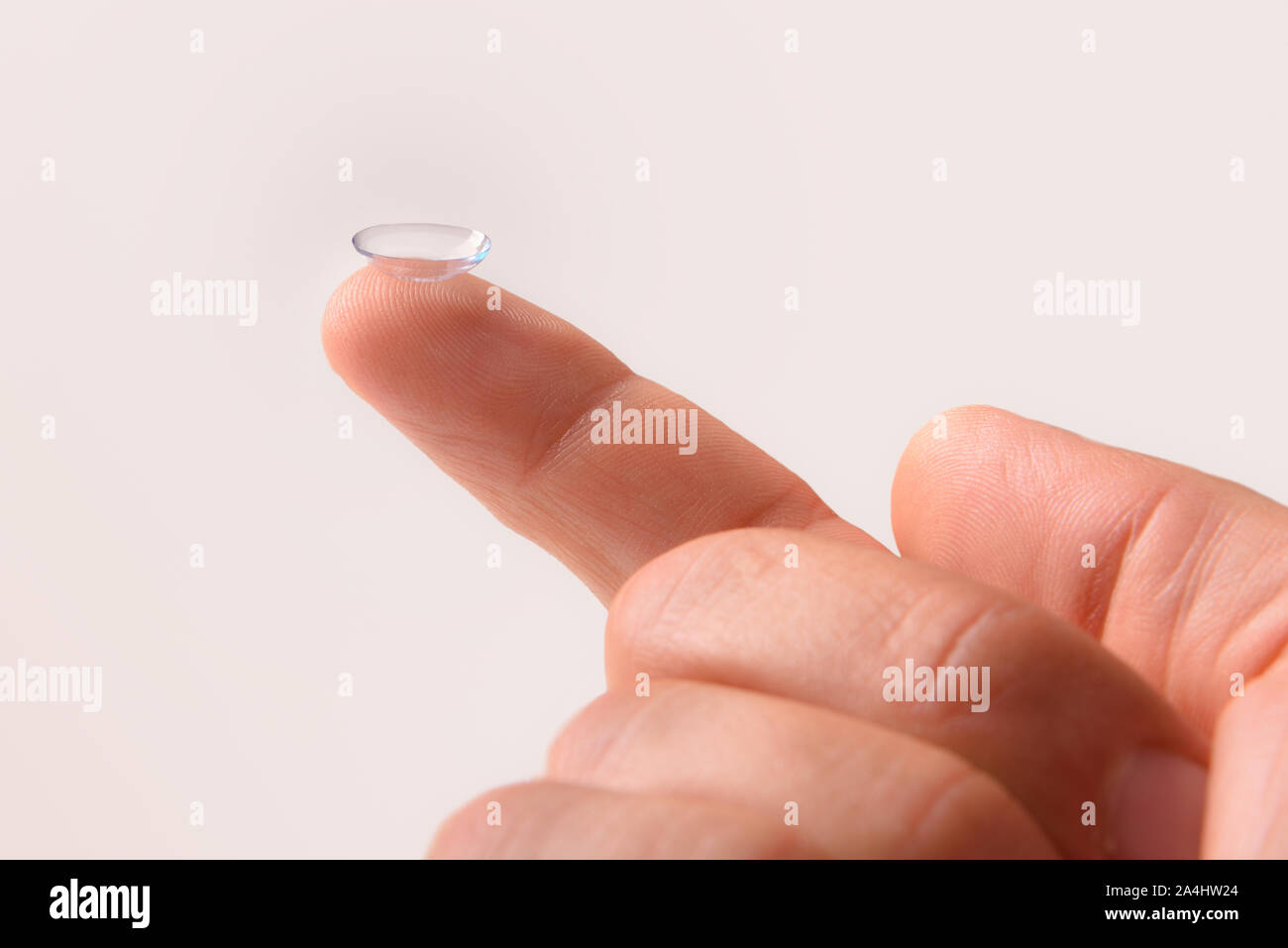Detail of hand with contact lens on finger with background isolated ...