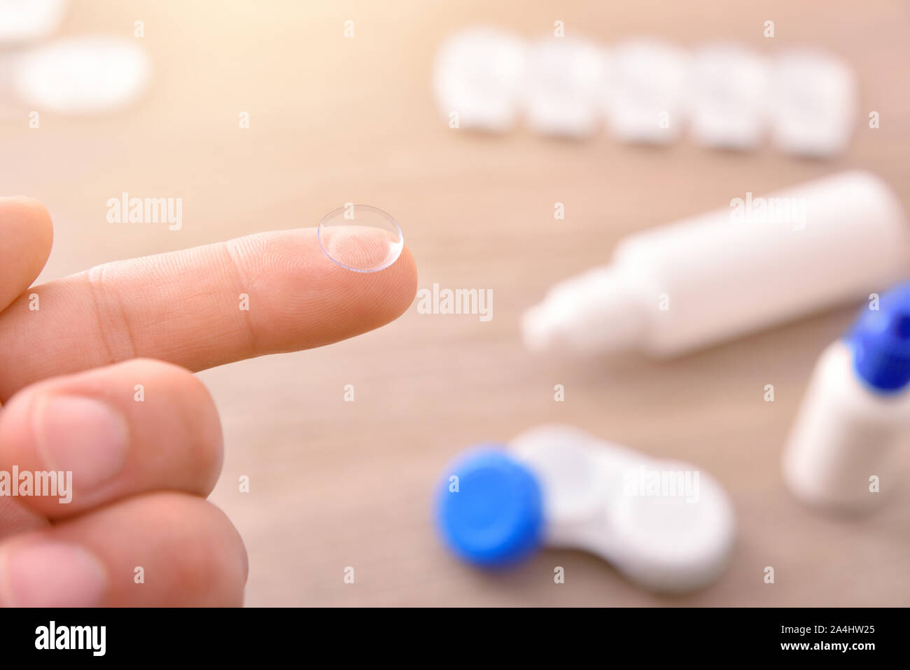 Hand with lens on the finger with background maintenance products ...