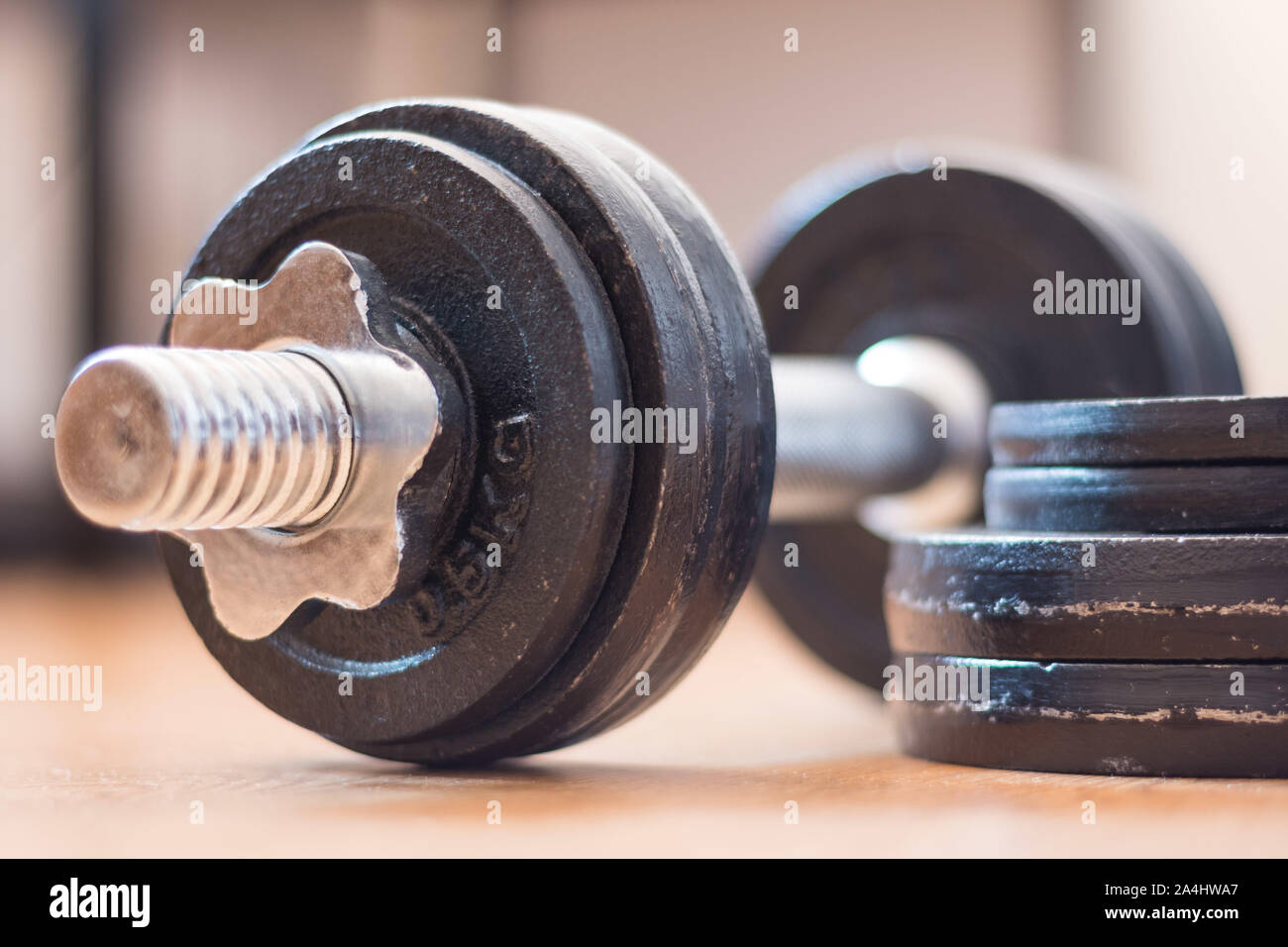 Black bar bell on the wooden floor, physical exercise Stock Photo - Alamy