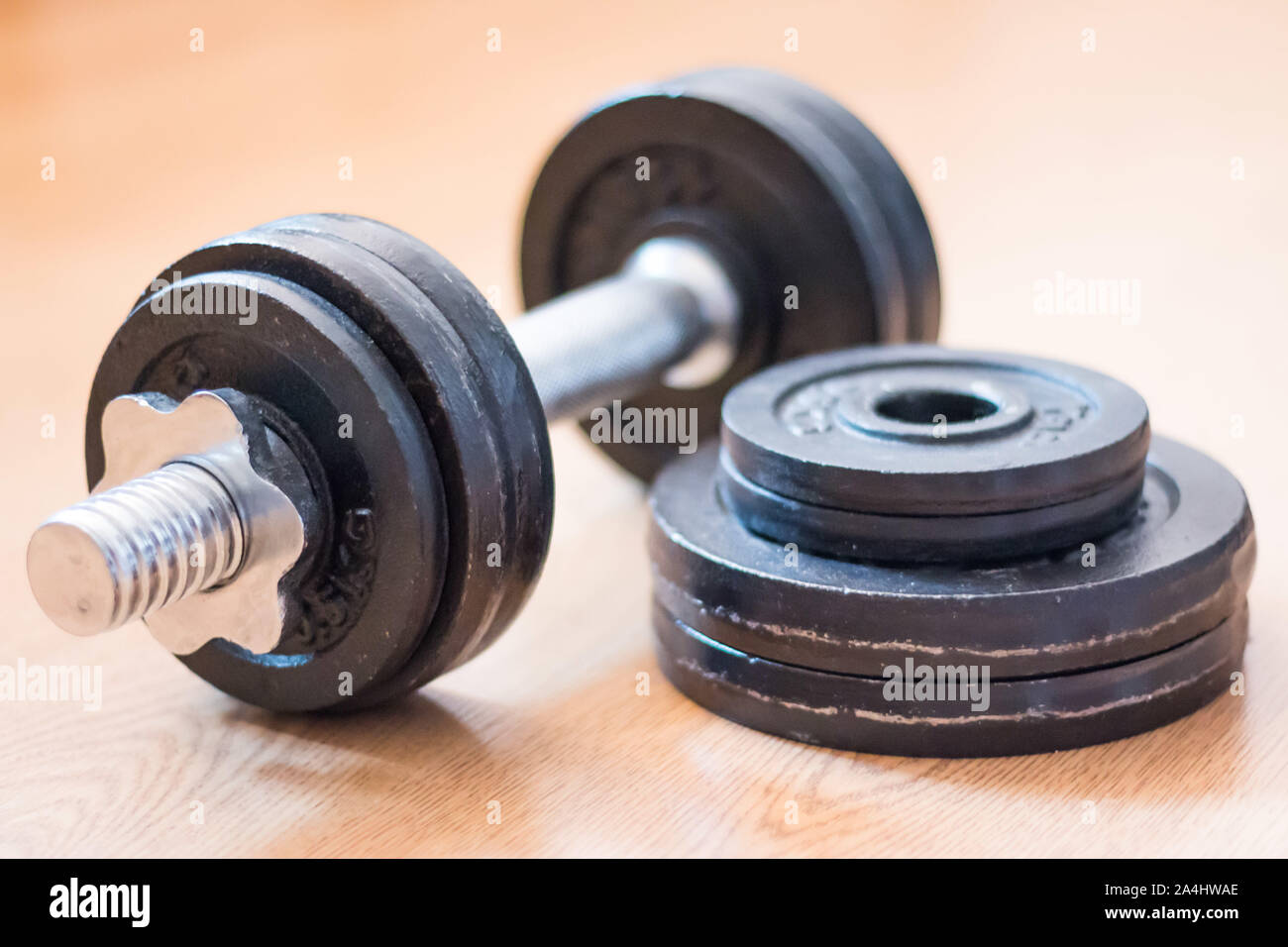 Black bar bell on the wooden floor, physical exercise Stock Photo - Alamy