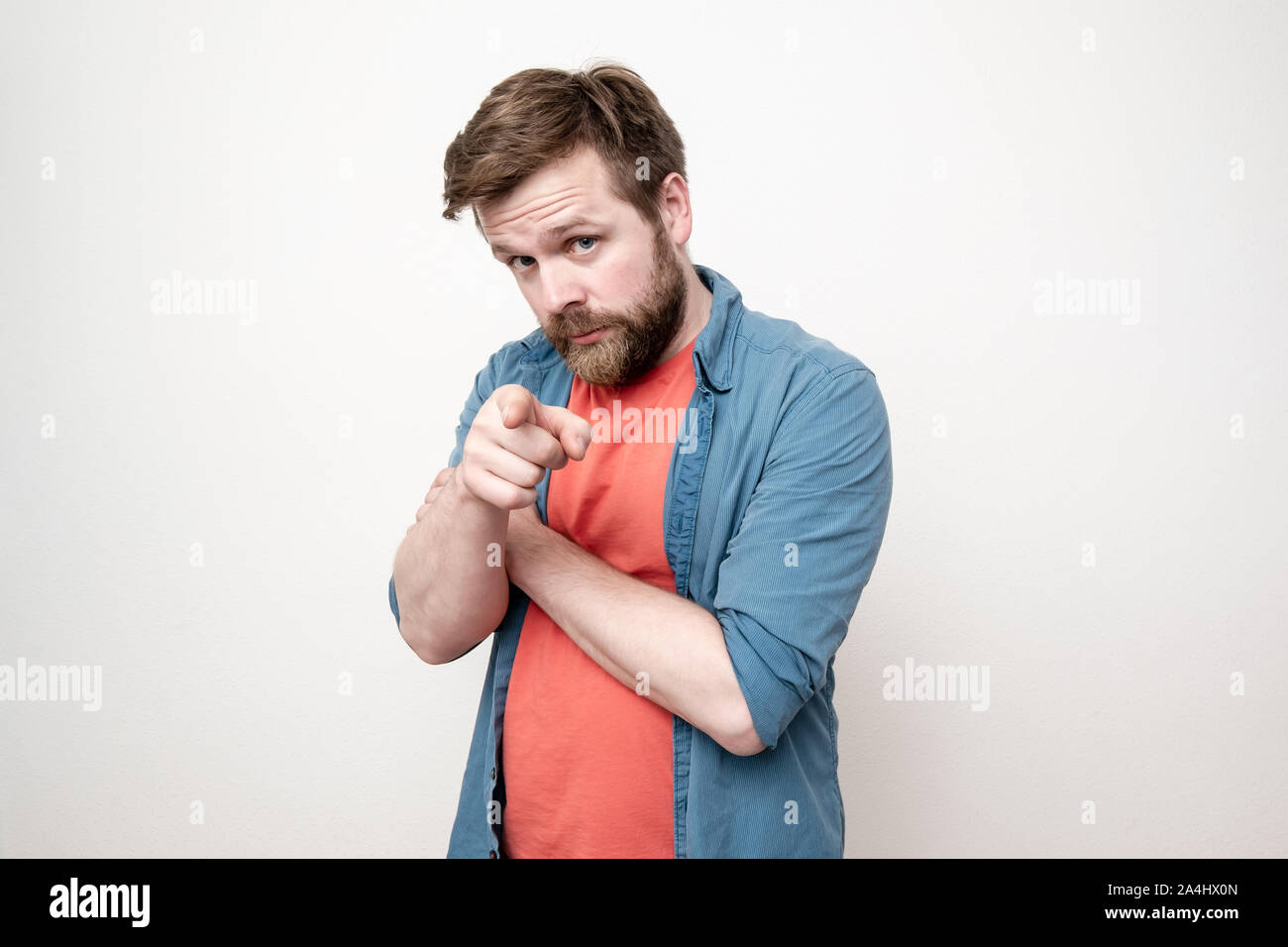Caucasian bearded man with a serious look confidently points a finger ...