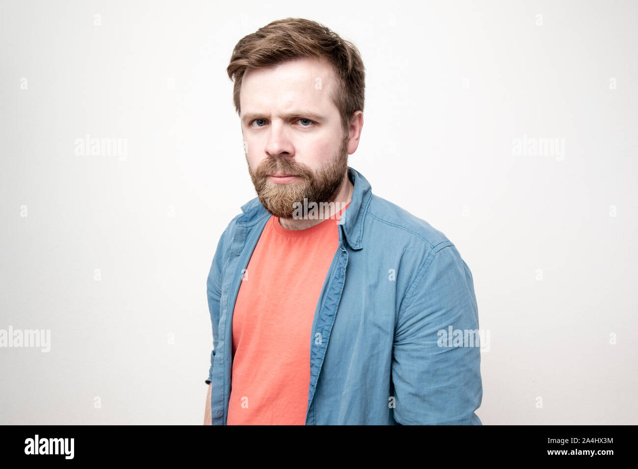 Cute, sad, bearded man looks upset and gloomy at the camera. Isolated ...