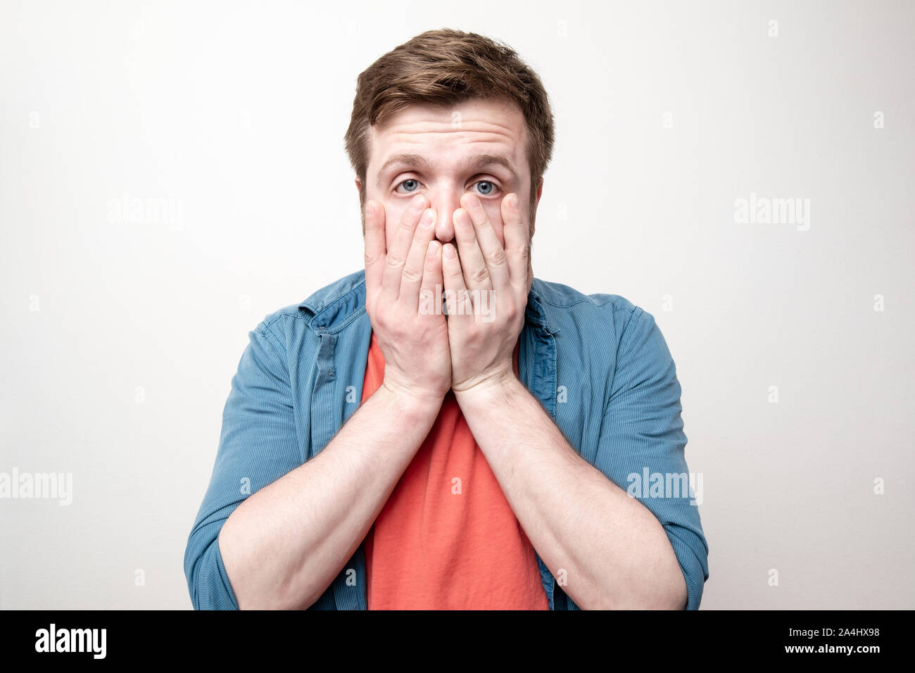 Tired man covers his face with his hands and sad eyes looks at the ...