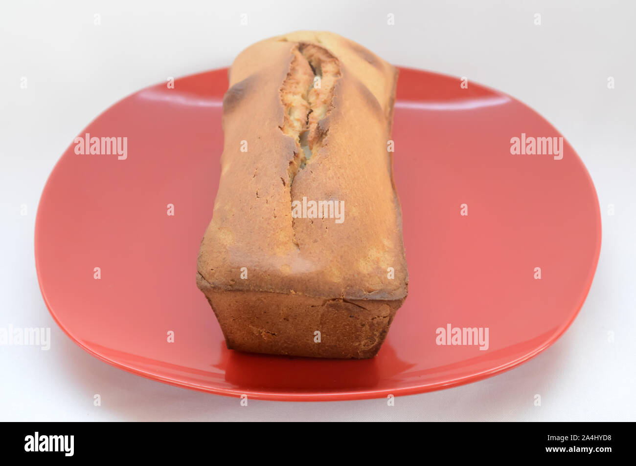 Whole homemade cake on a red background Stock Photo - Alamy