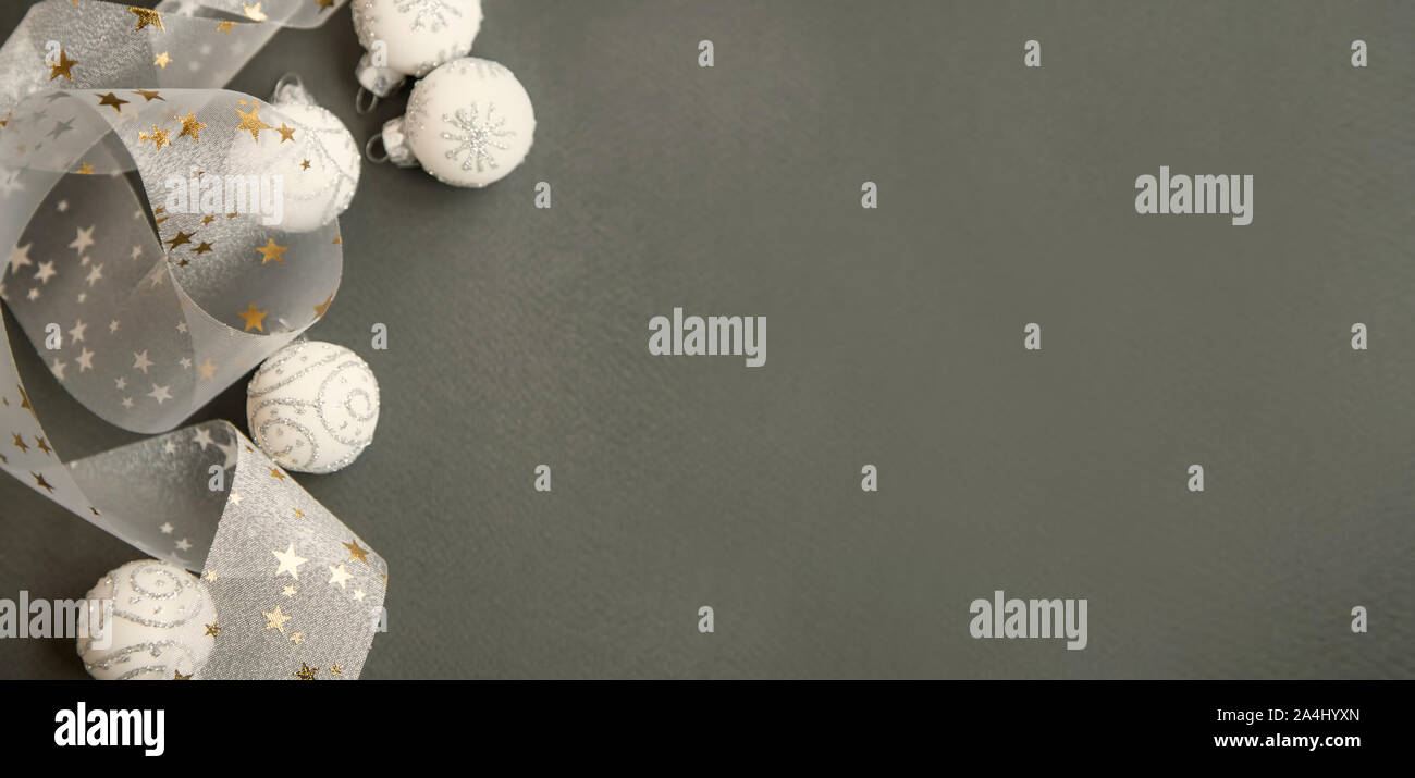 Festive Christmas greeting with globes and ribbon on grey background ...