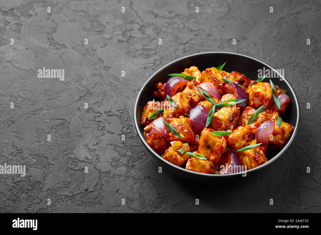 Schezwan Paneer in black bowl at dark slate background. Schezwan Paneer ...
