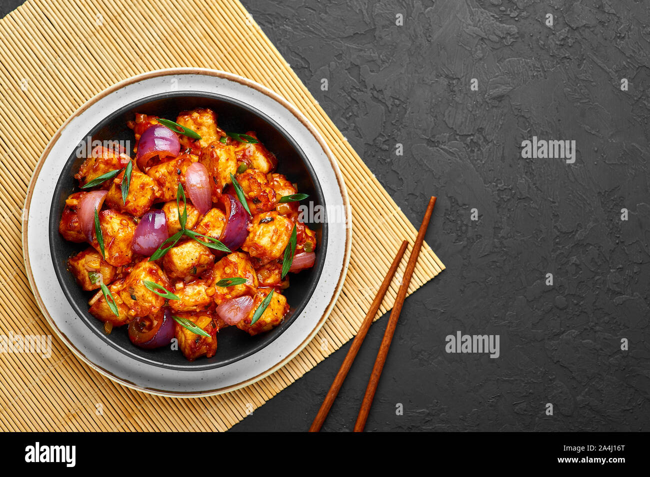 Schezwan Paneer in black bowl at dark slate background. Schezwan Paneer ...