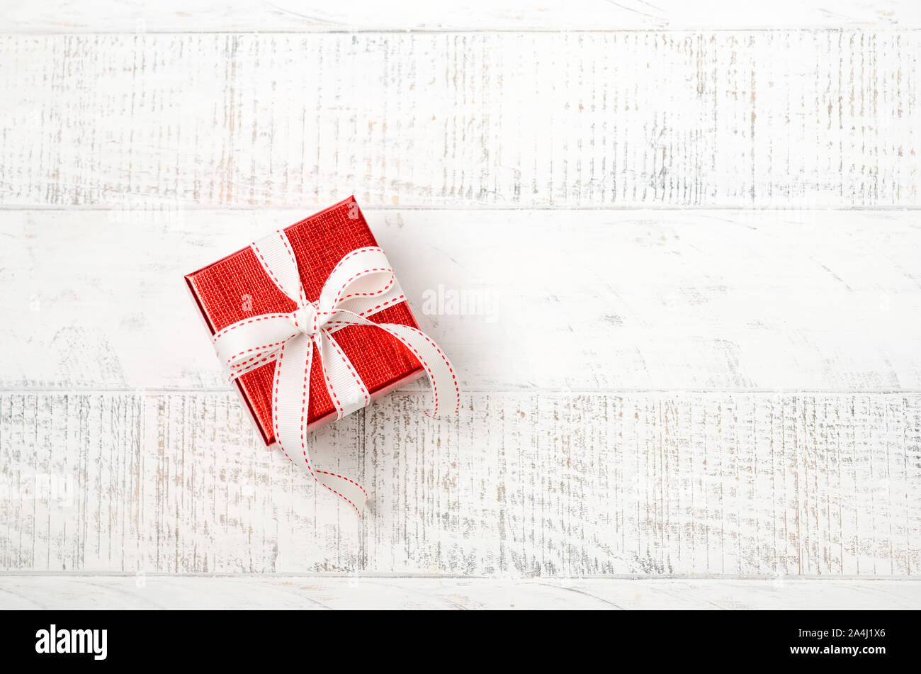 Christmas background with red gift box on a white wooden background ...