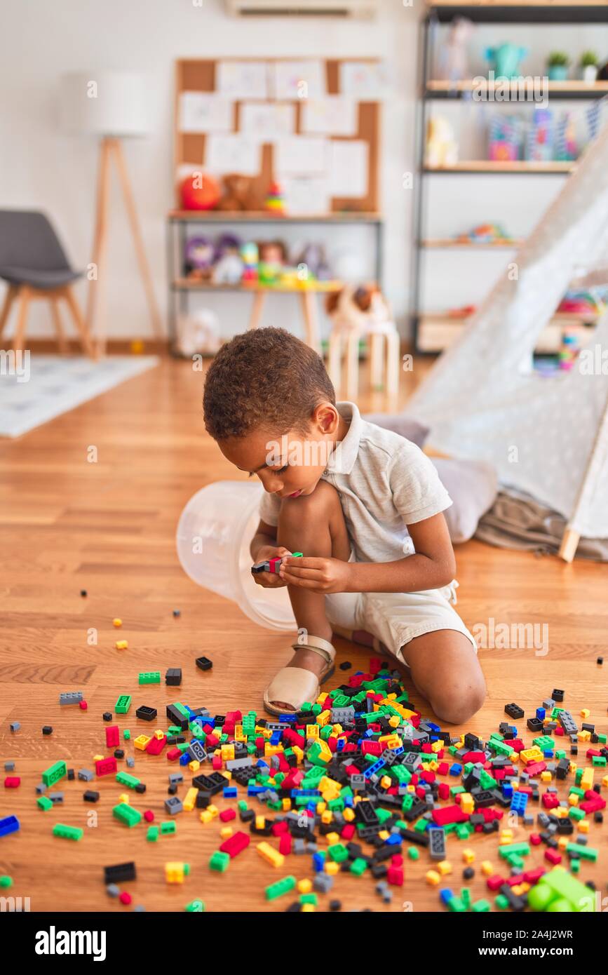 Beautiful african american toddler playing with small building blocks ...