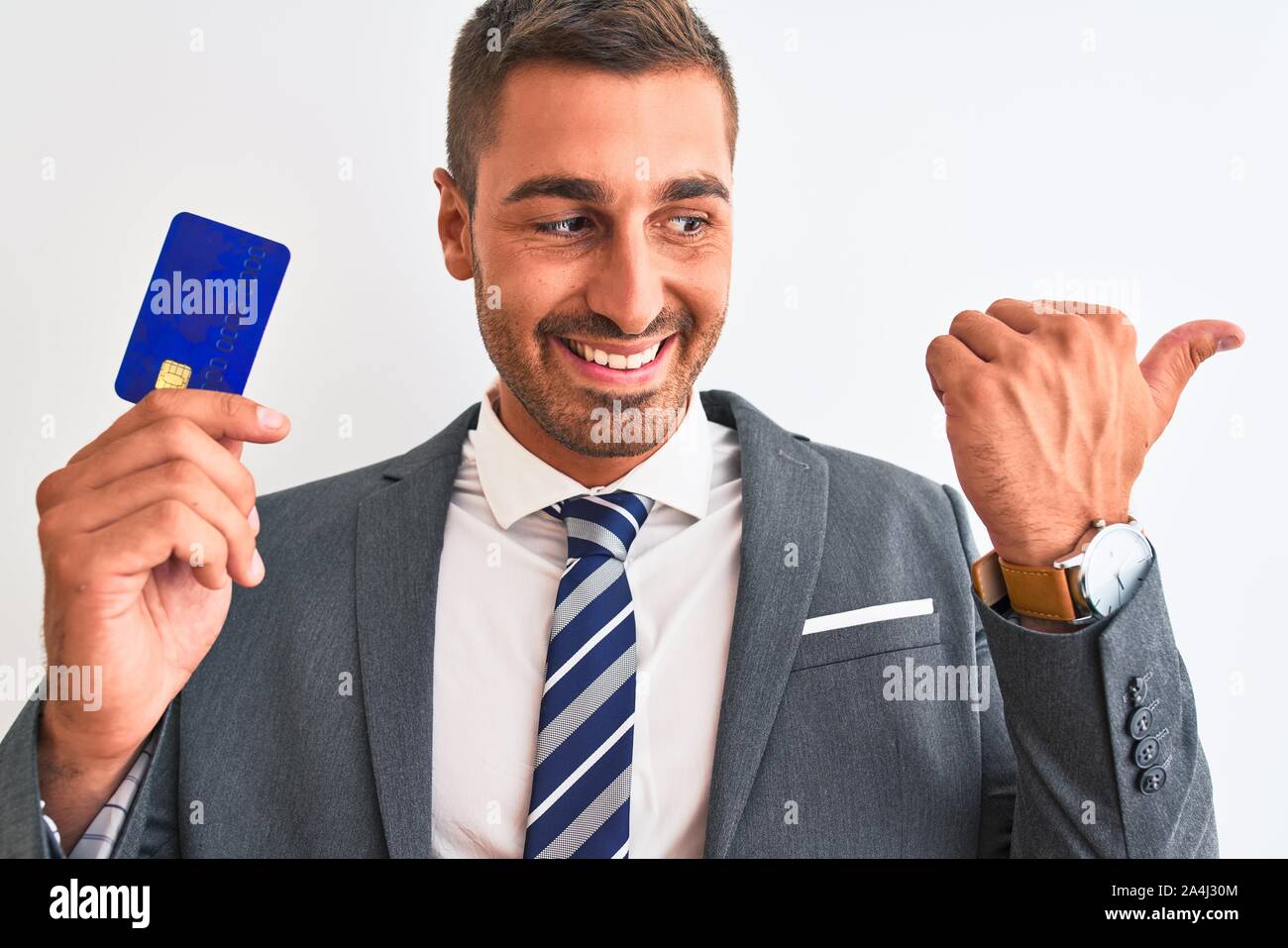 Young handsome business man holding credit card over isolated ...