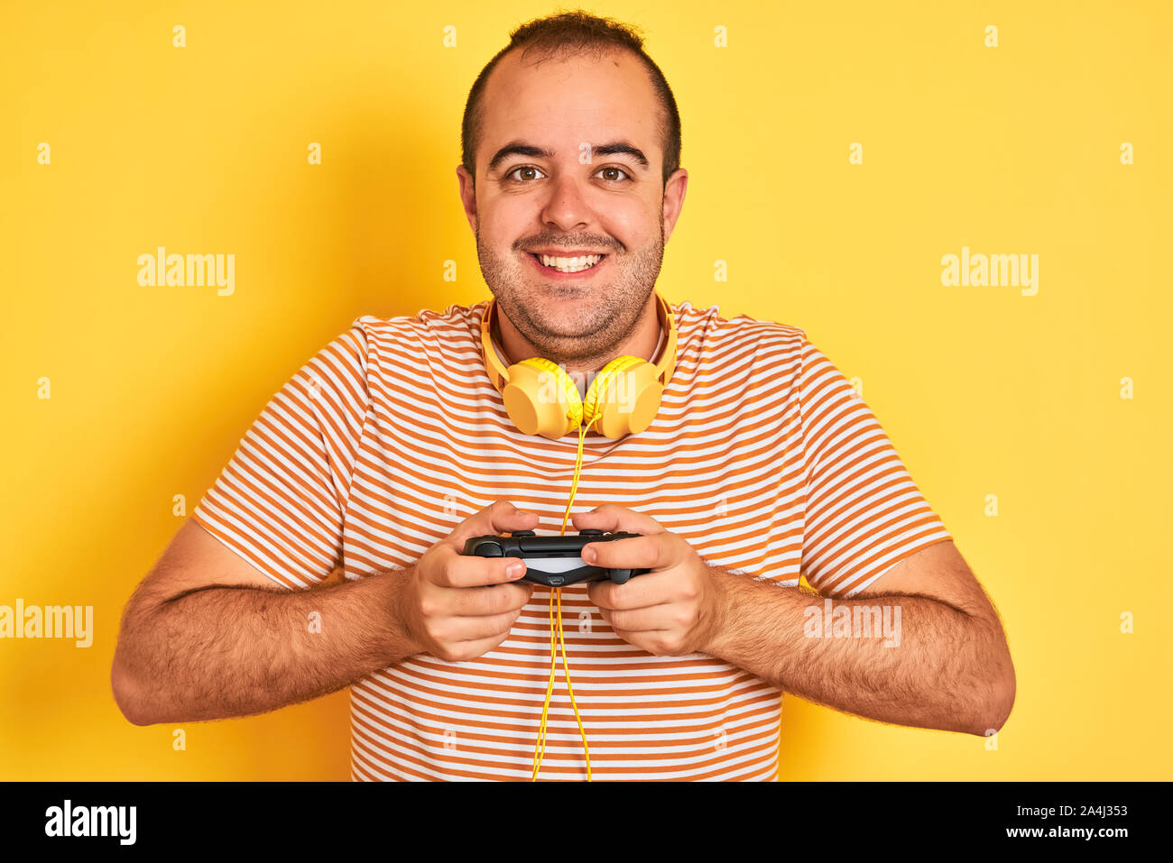 Young gamer man playing video game using headphones over isolated ...