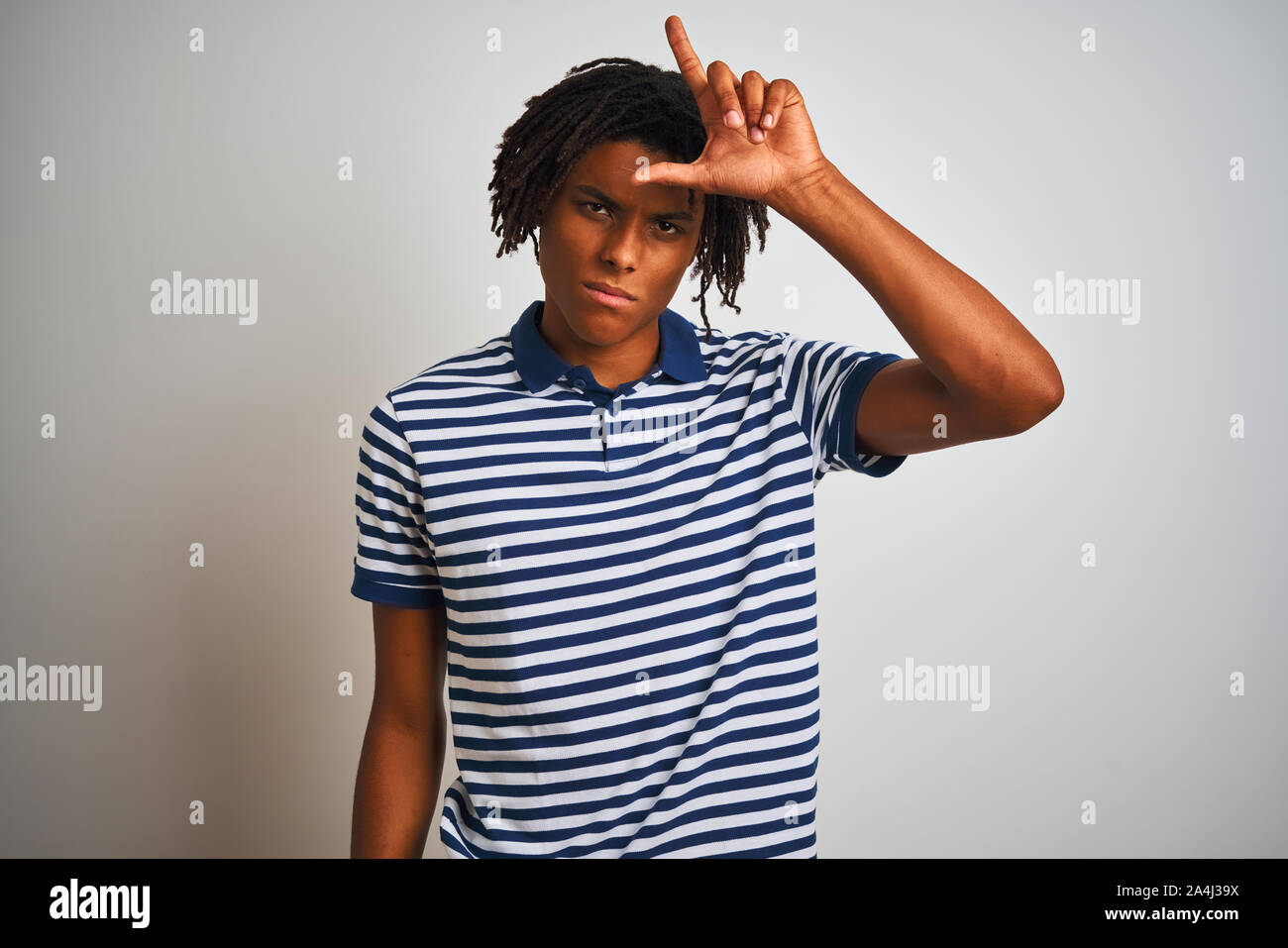 Afro man with dreadlocks wearing striped blue polo standing over ...