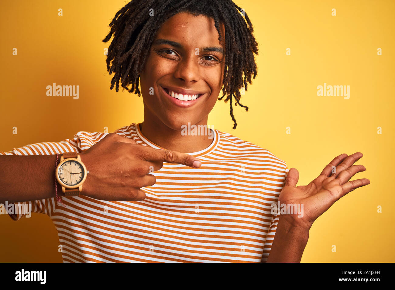 Afro man with dreadlocks wearing striped t-shirt standing over isolated ...
