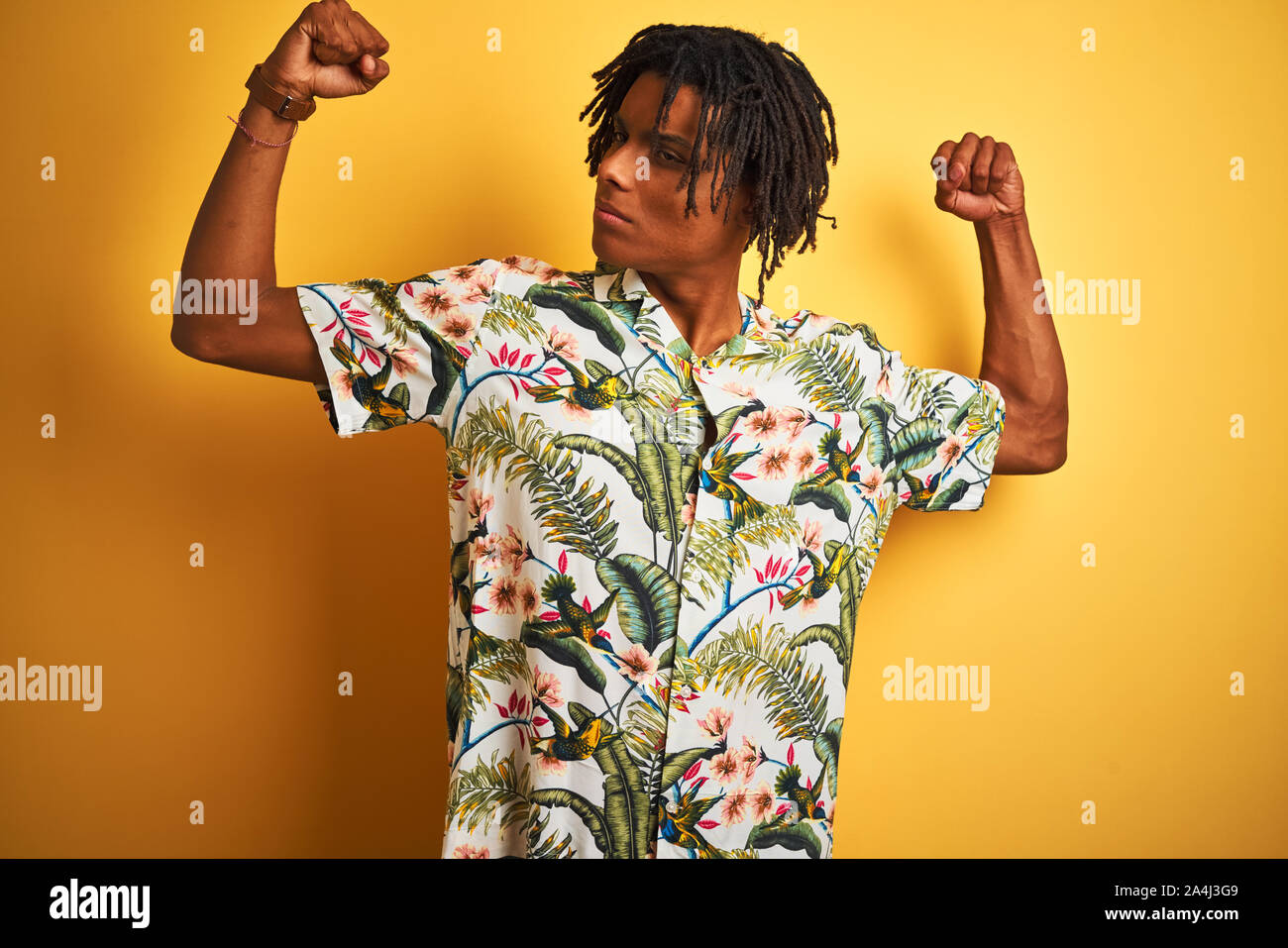 Afro man with dreadlocks on vacation wearing summer shirt over isolated ...