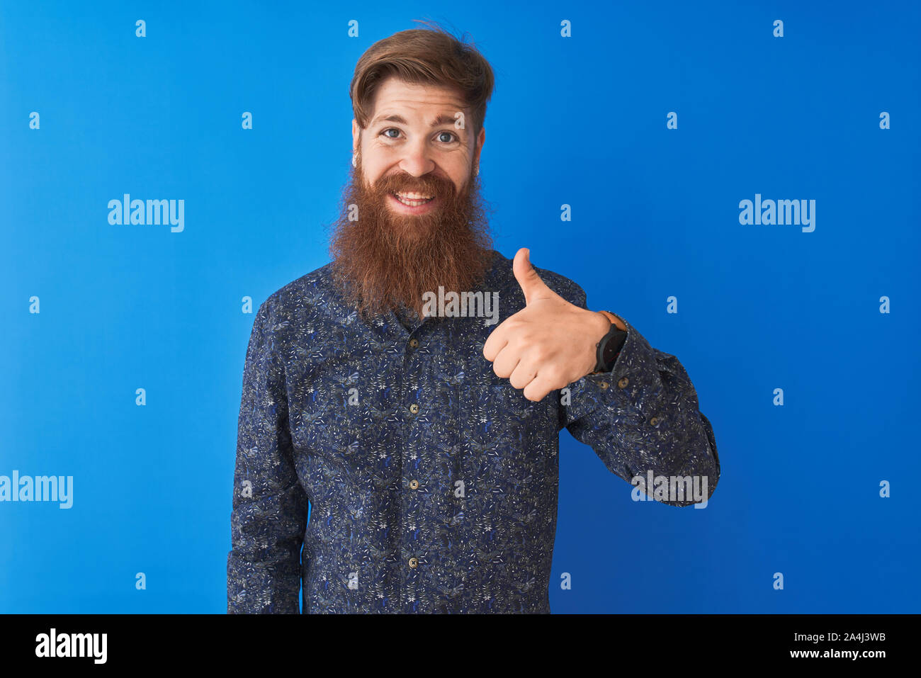 Young redhead irish man wearing floral summer shirt standing over ...