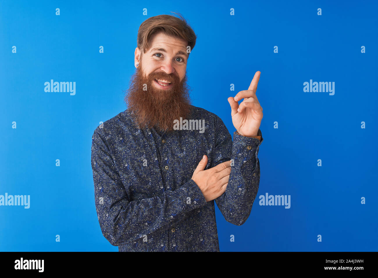 Young redhead irish man wearing floral summer shirt standing over ...
