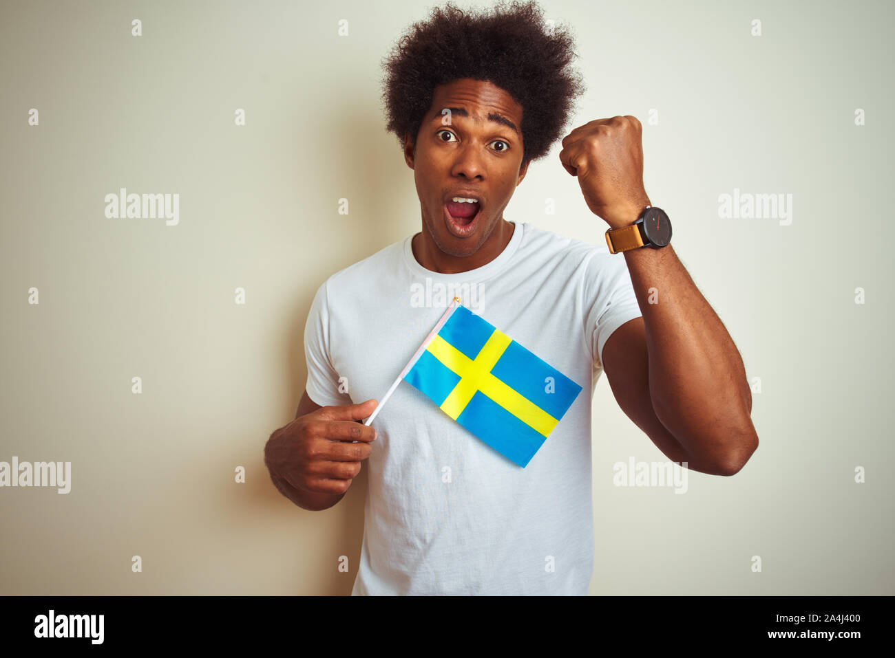 Young afro american man holding Sweden Swedish flag standing over ...