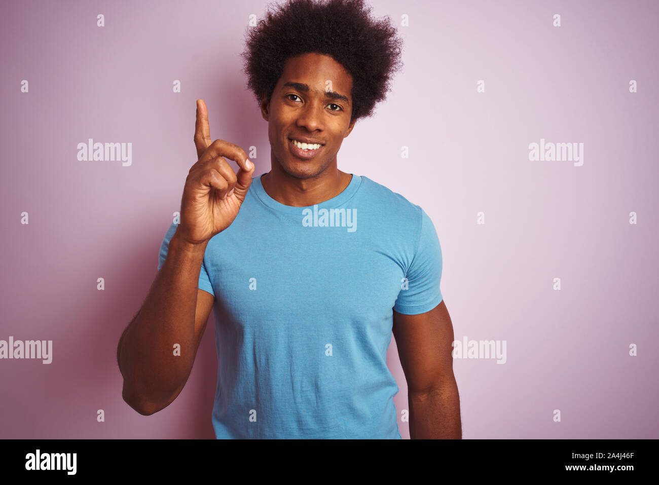 African american man with afro hair wearing blue t-shirt standing over ...
