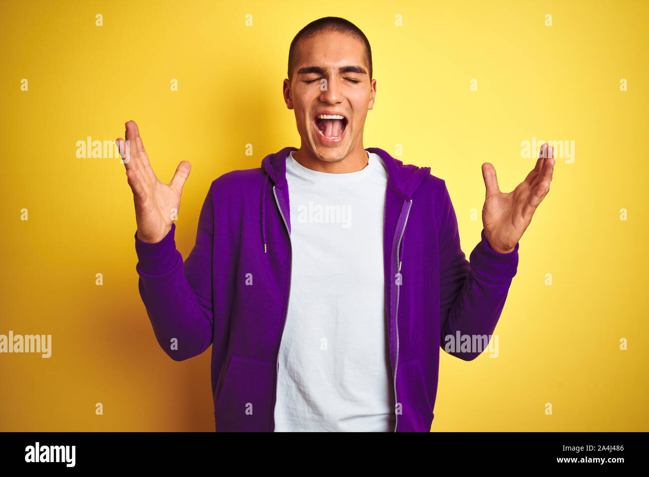 Young handsome man wearing purple sweatshirt over yellow isolated ...