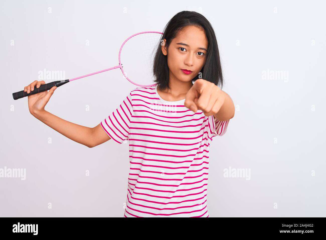 Young beautiful chinese woman holding badminton racket over isolated ...