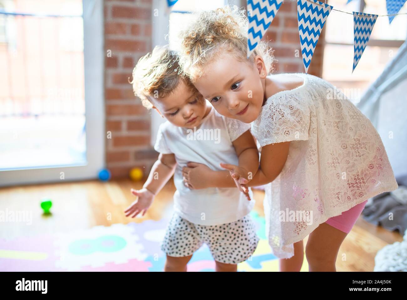 Beautiful toddlers smiling happy standing around lots of toys at ...