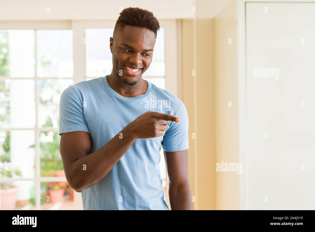 Handsome african young man smiling cheerful pointing with arms and ...