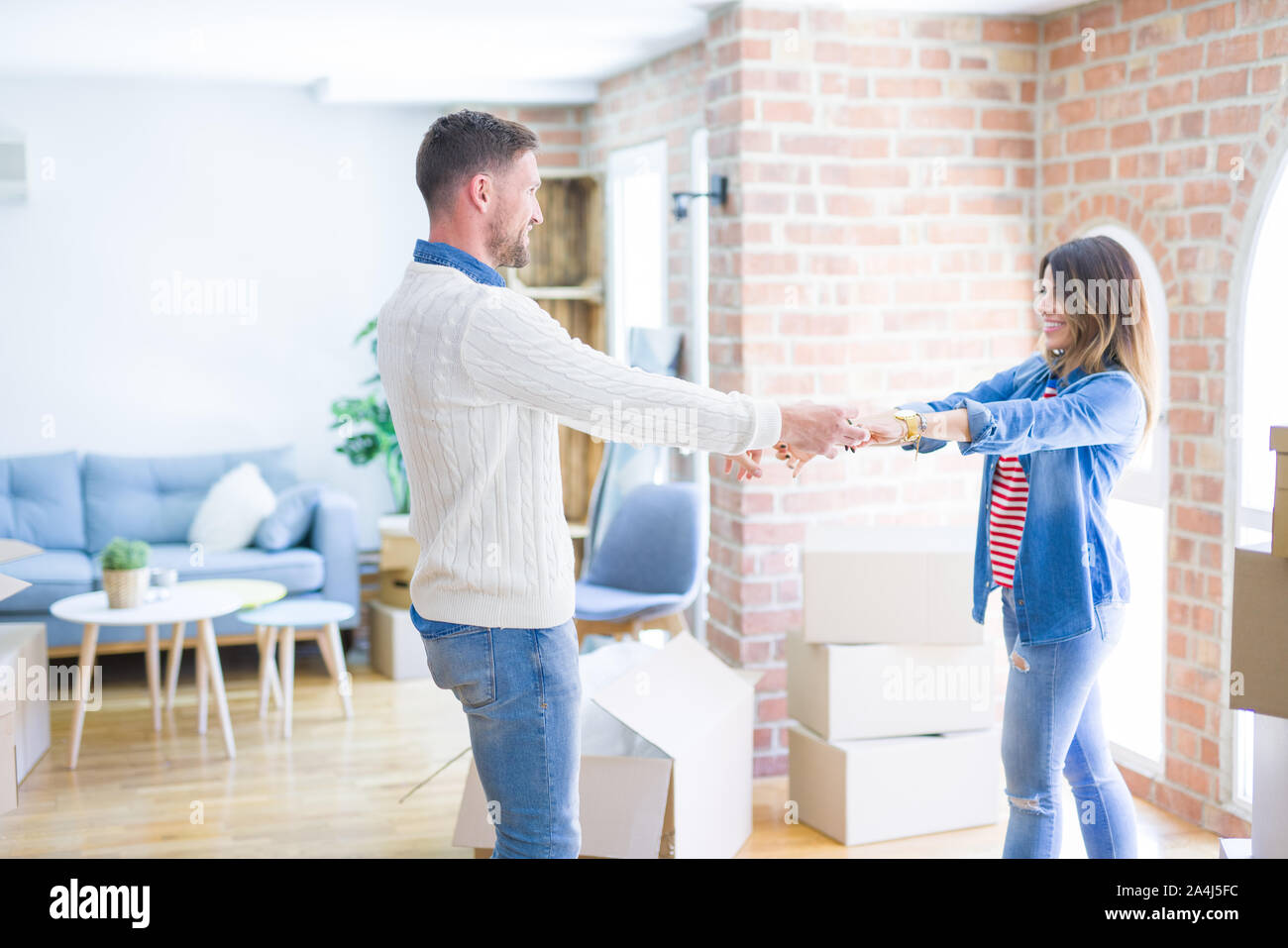 Young beautiful couple dancing at new home around cardboard boxes Stock ...