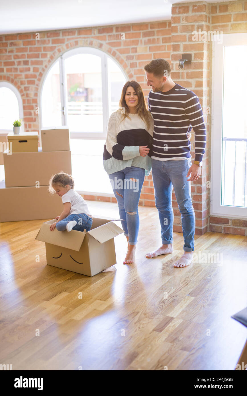 Beautiful famiily, kid playing with his parents riding fanny cardboard ...